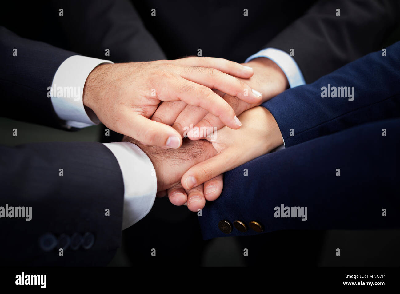 Business team showing union with their hands together forming a pile ...