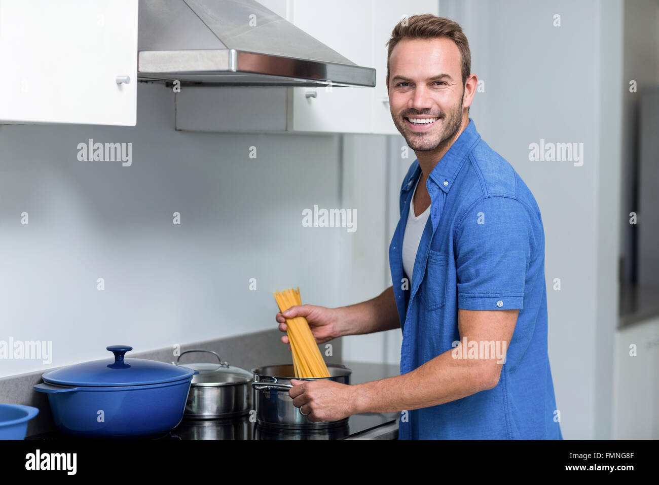 Young man cooking spaghetti Stock Photo - Alamy