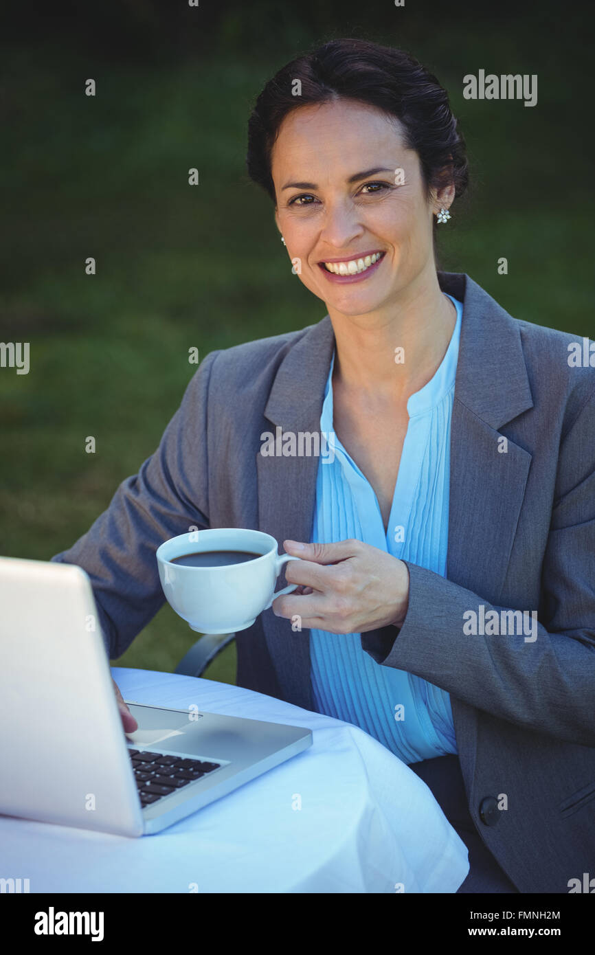 Pretty businesswoman having coffee and using laptop Stock Photo - Alamy