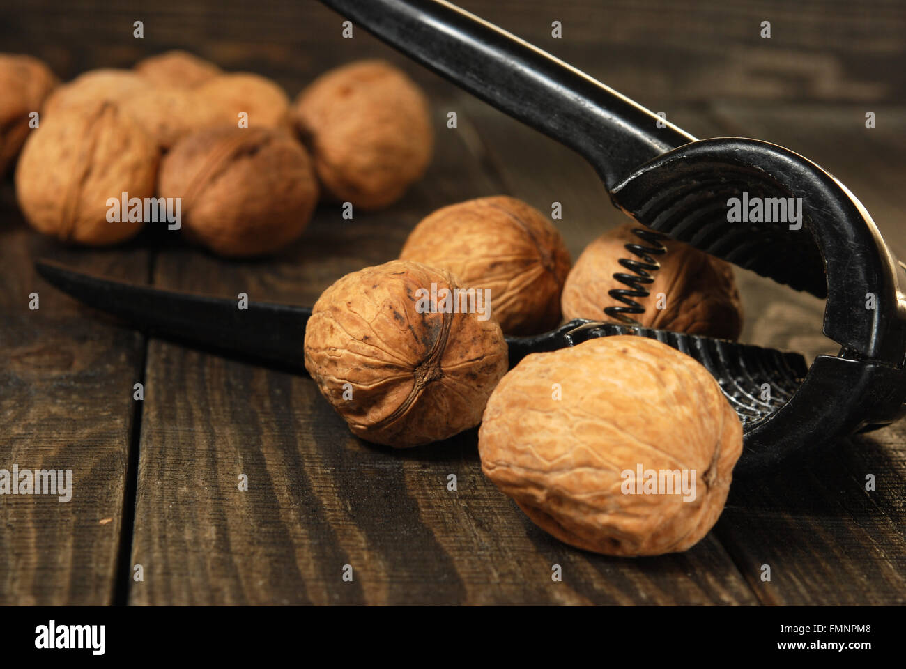 Walnuts on the dark wooden background with the tool for chopping Stock ...