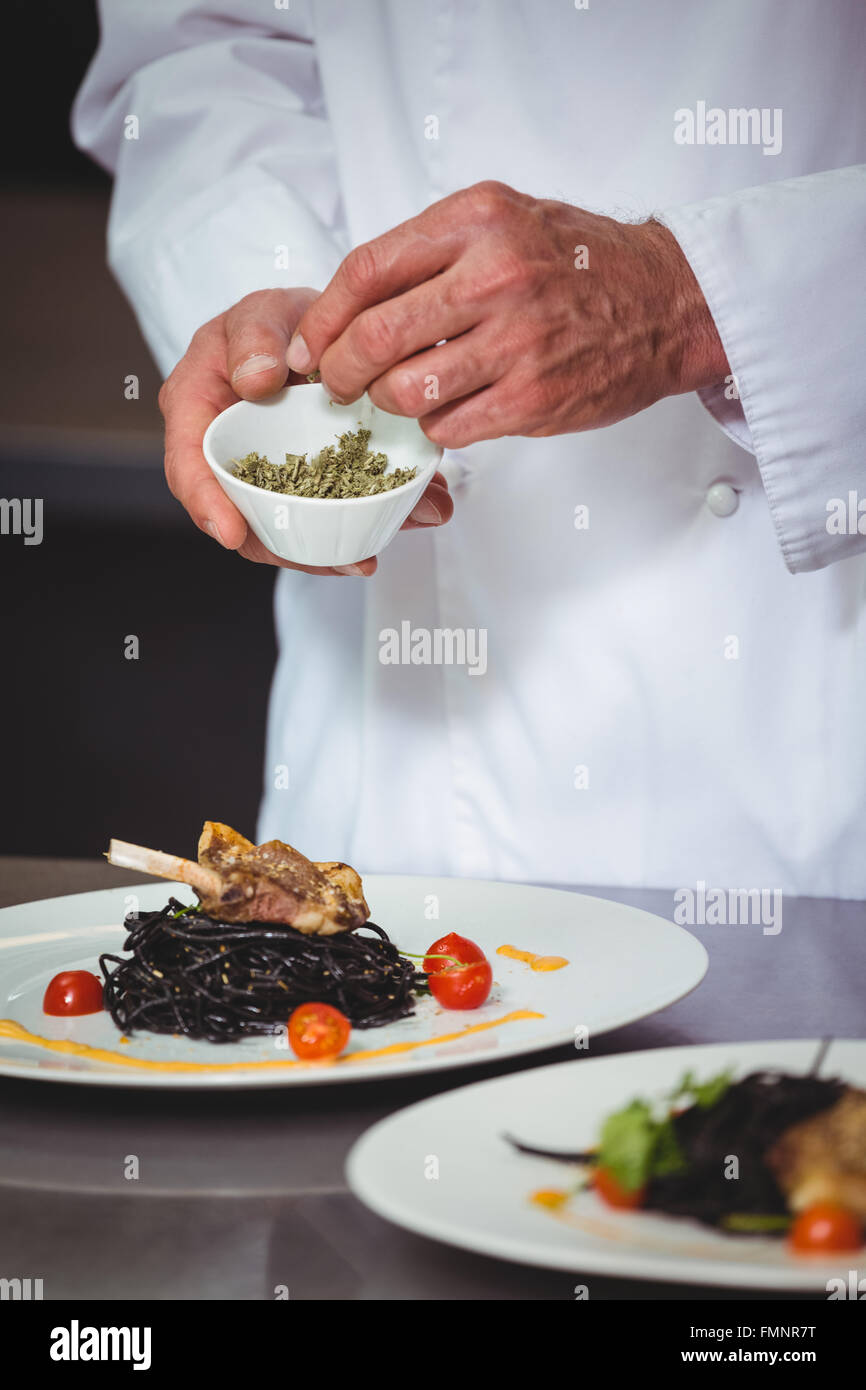 Chef sprinkling spices on dish Stock Photo - Alamy