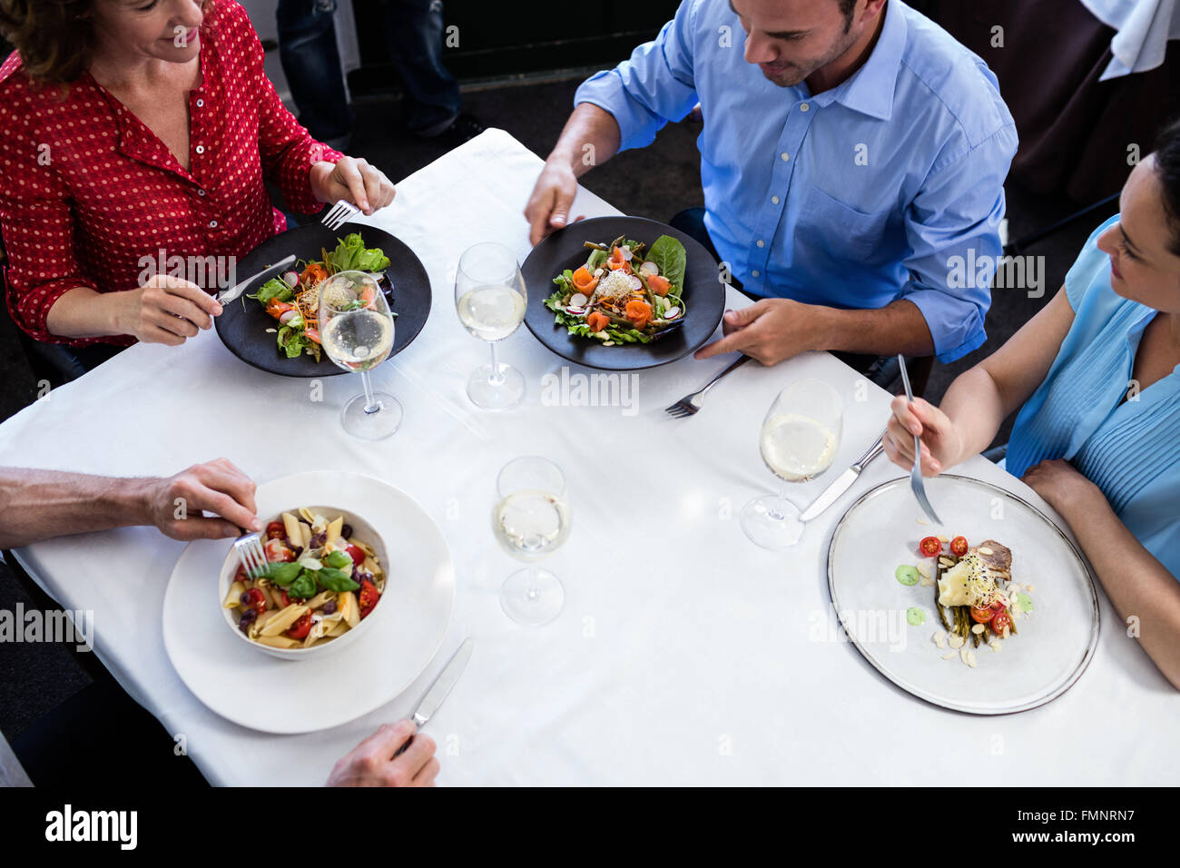 Group of friends talking while having lunch Stock Photo - Alamy