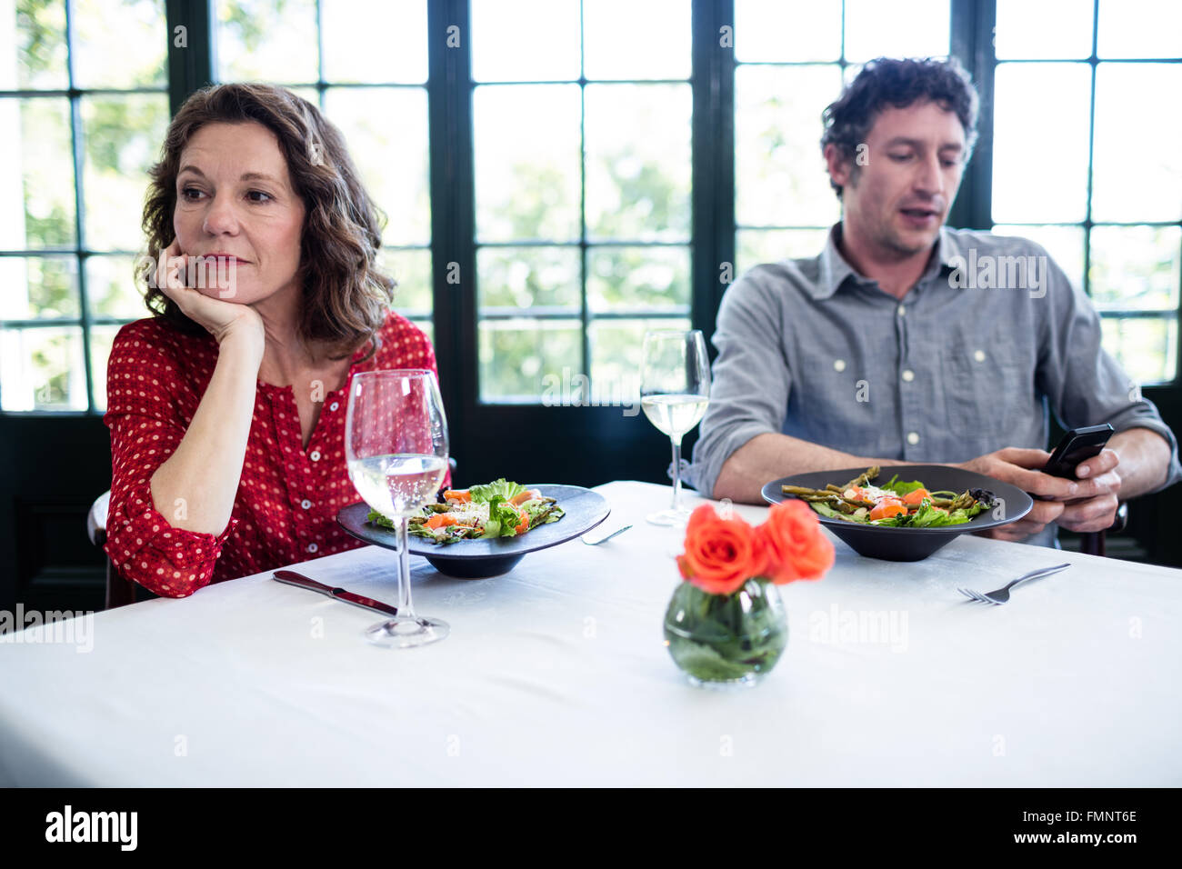 Woman feeling bored while man using his phone Stock Photo - Alamy