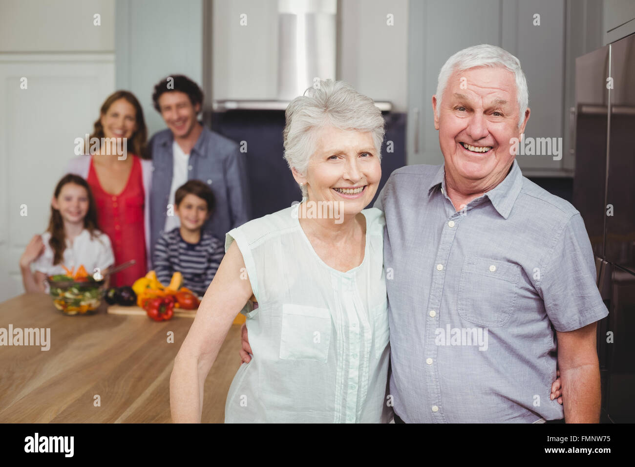 Portrait of smiling grandparents with family in kitchen Stock Photo - Alamy