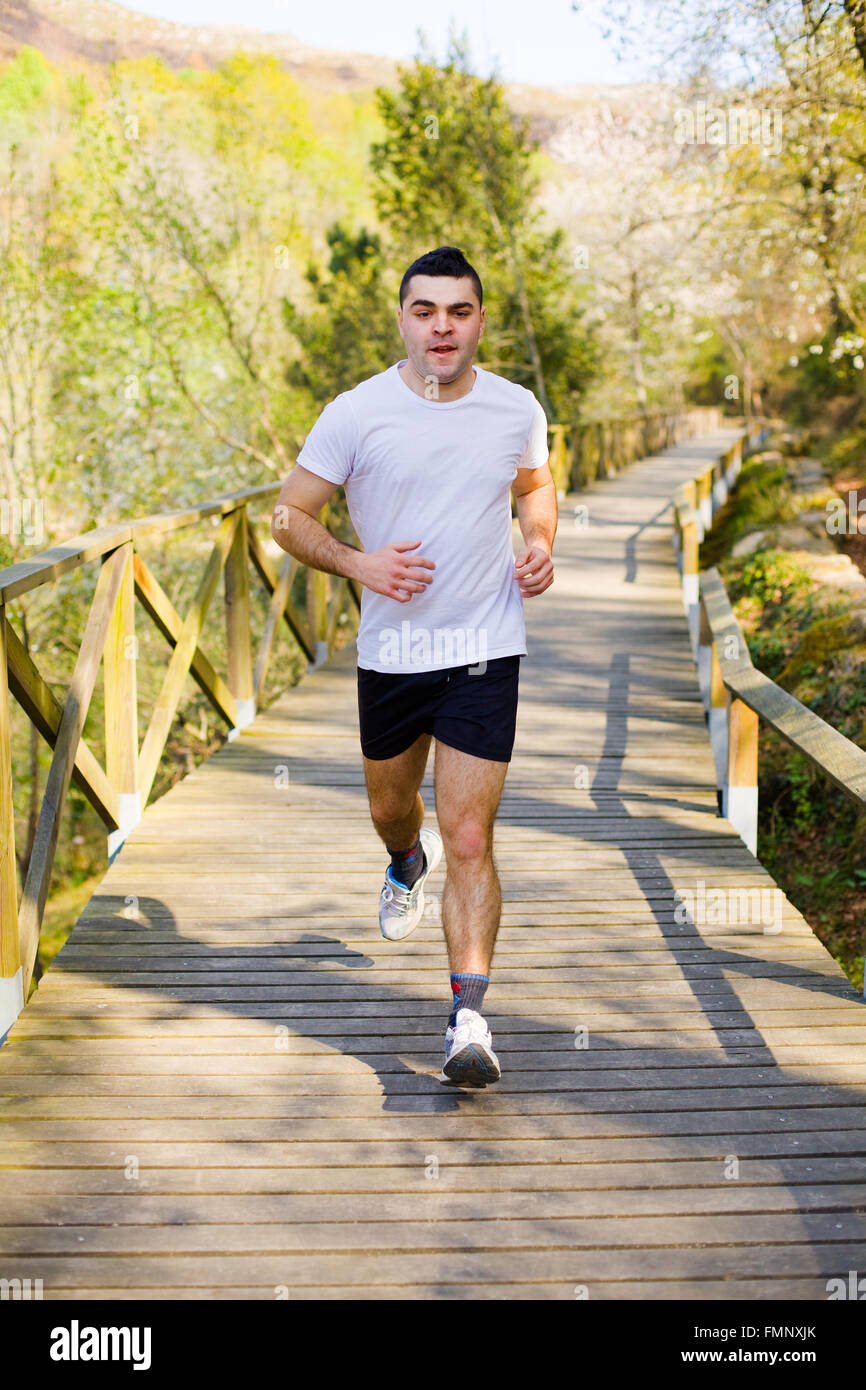 Young man running at the park Stock Photo - Alamy