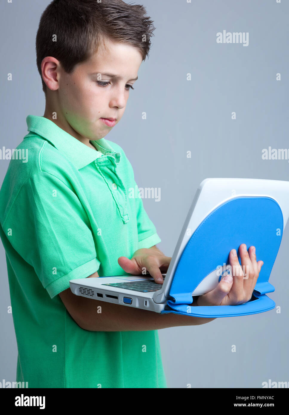 Boy with laptop on grey background Stock Photo - Alamy