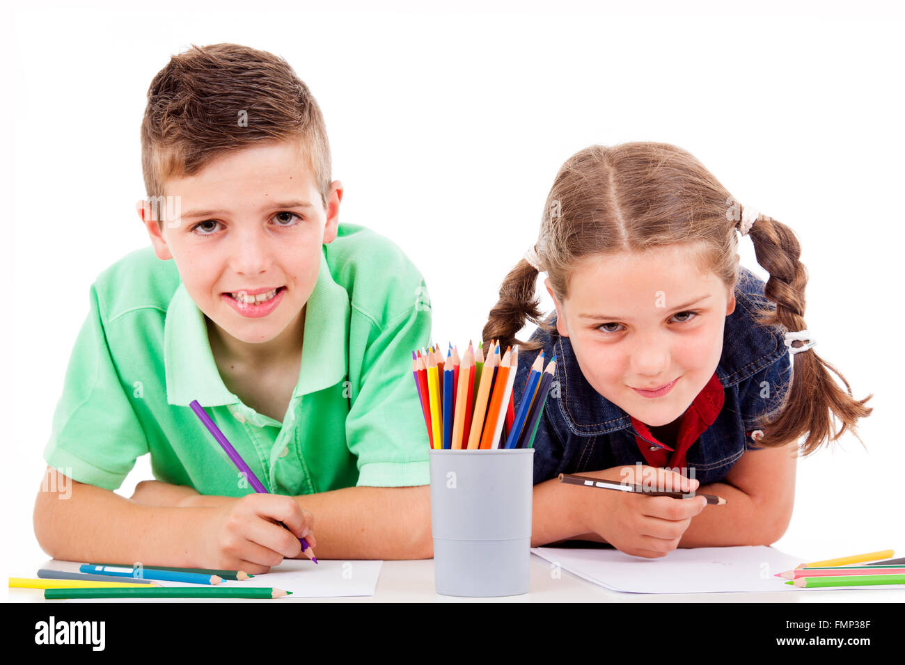 Two children draw with colorful crayons and smile, isolated over white ...
