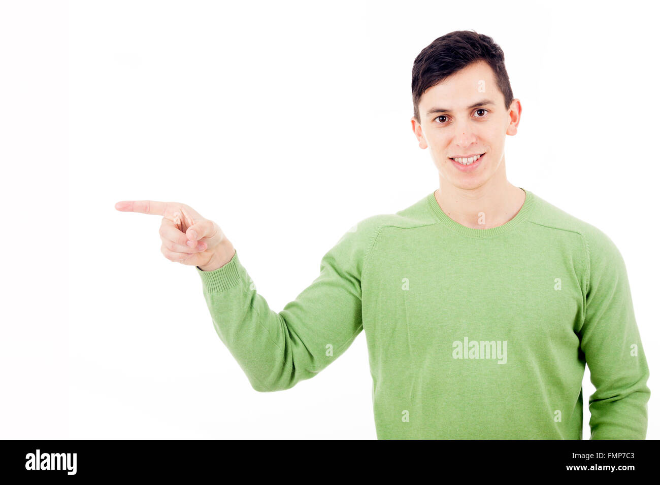 Young casual man pointing at copy space isolated on white background ...