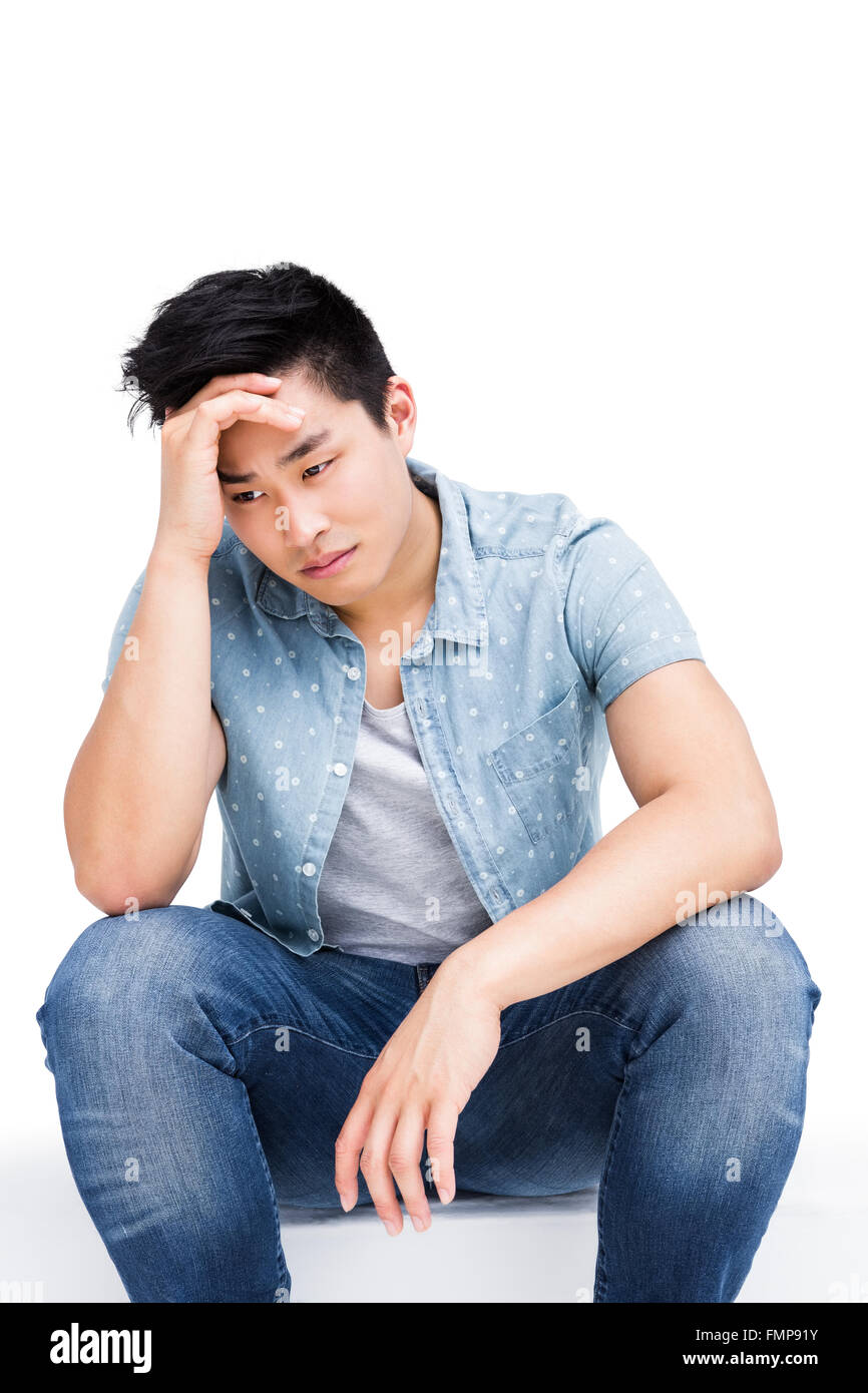 Frustrated man sitting with his hand on head Stock Photo - Alamy