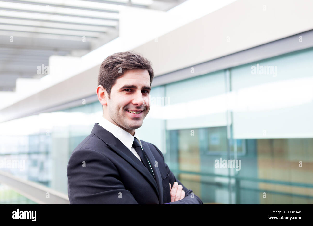 Young business man smiling at the office Stock Photo - Alamy