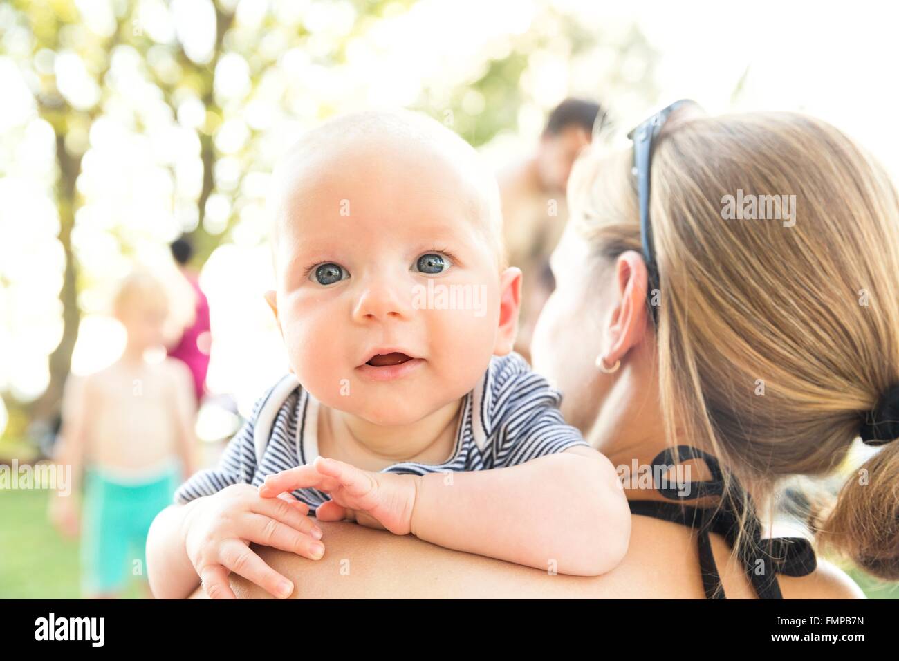 Baby looking over the shoulder of the mother Stock Photo - Alamy