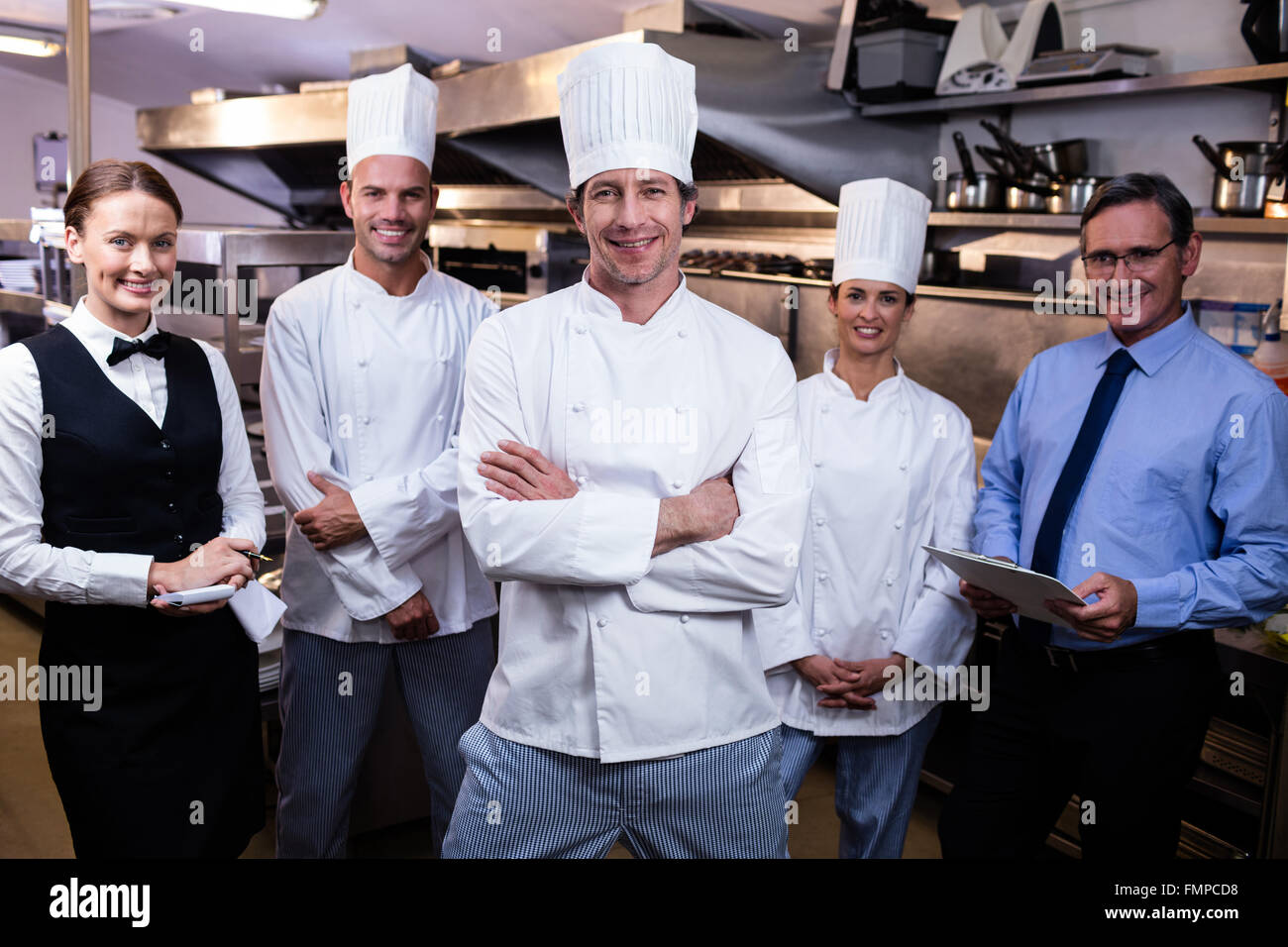 Happy restaurant team standing together in commercial kitchen Stock ...