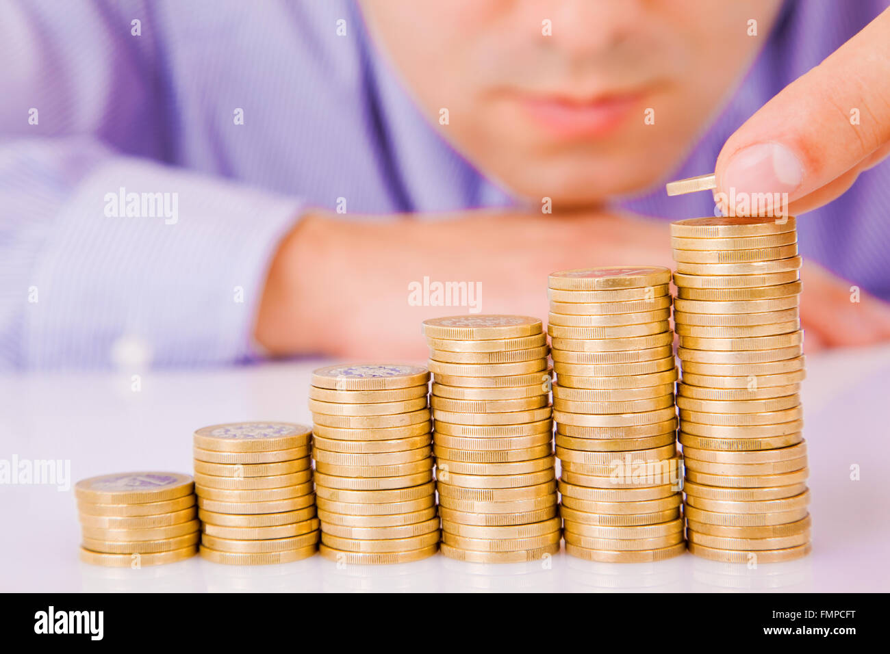 Business man rising coins Stock Photo - Alamy