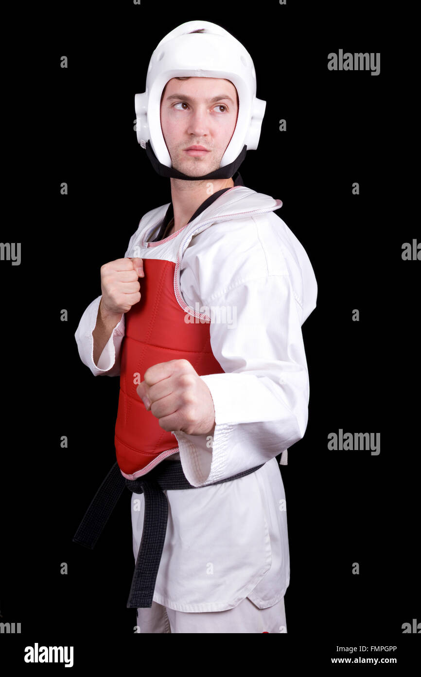 Young man in Taekwondo gear standing against black background Stock ...