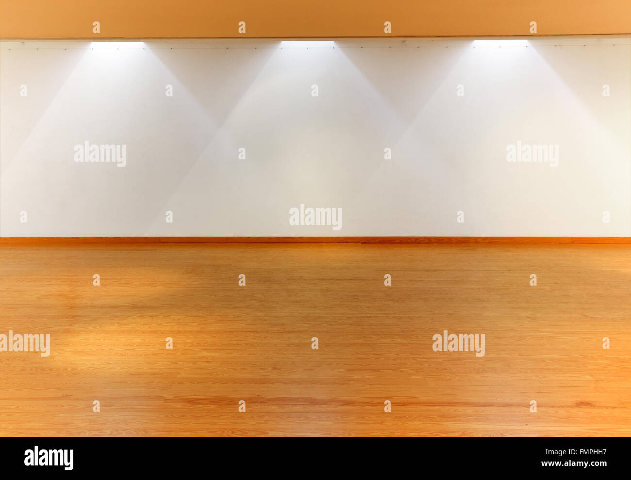 Empty white wall with spot lights and wooden floor Stock Photo - Alamy