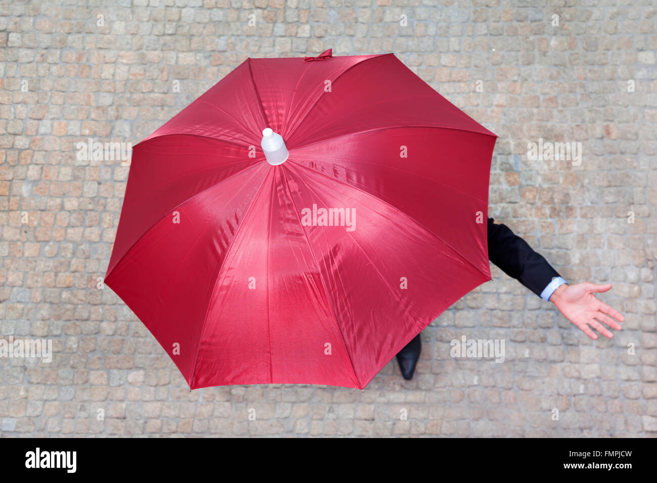 Businessman hidden under umbrella and checking if it's raining Stock ...