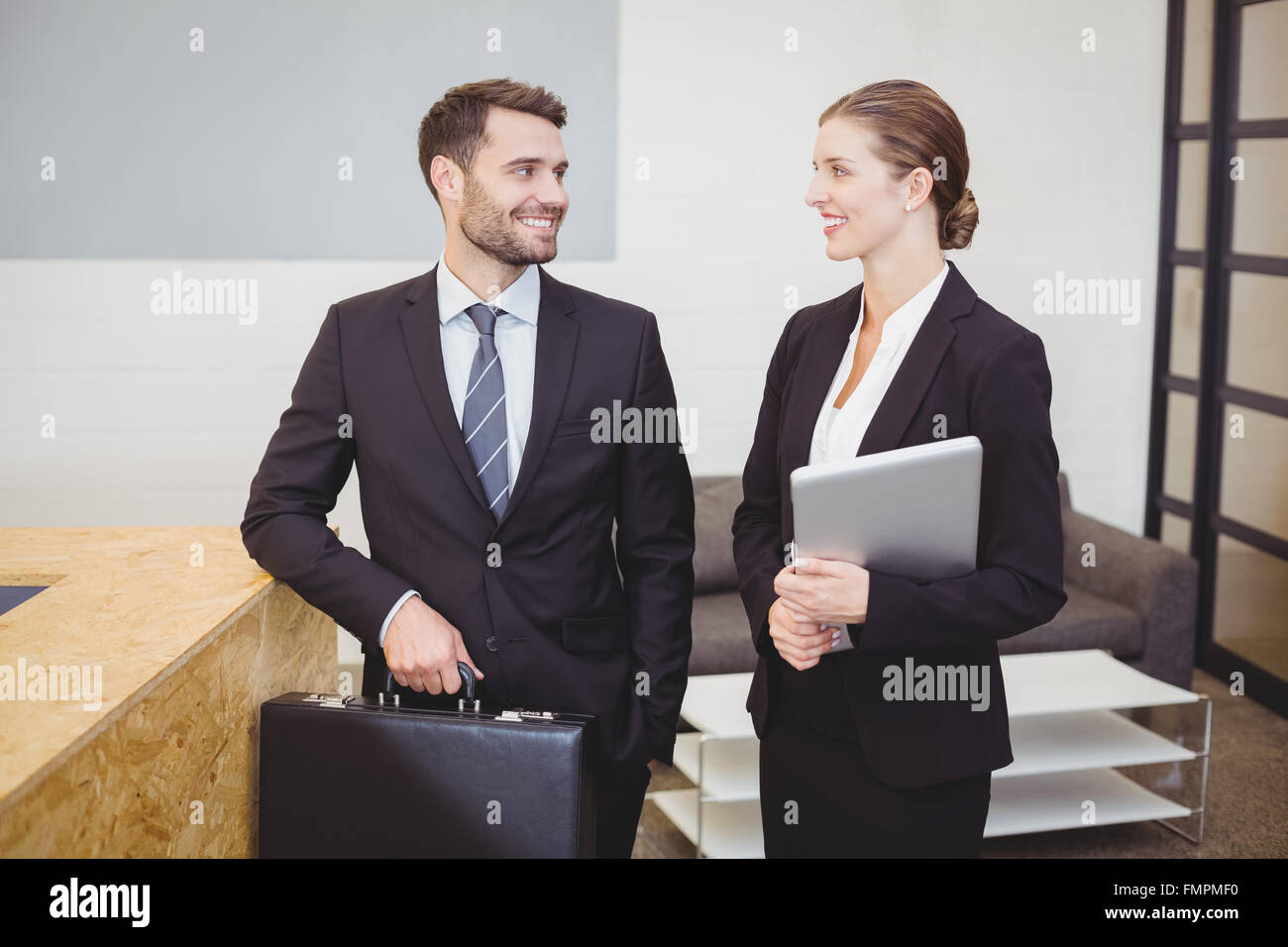 Business people smiling while talking in office Stock Photo - Alamy