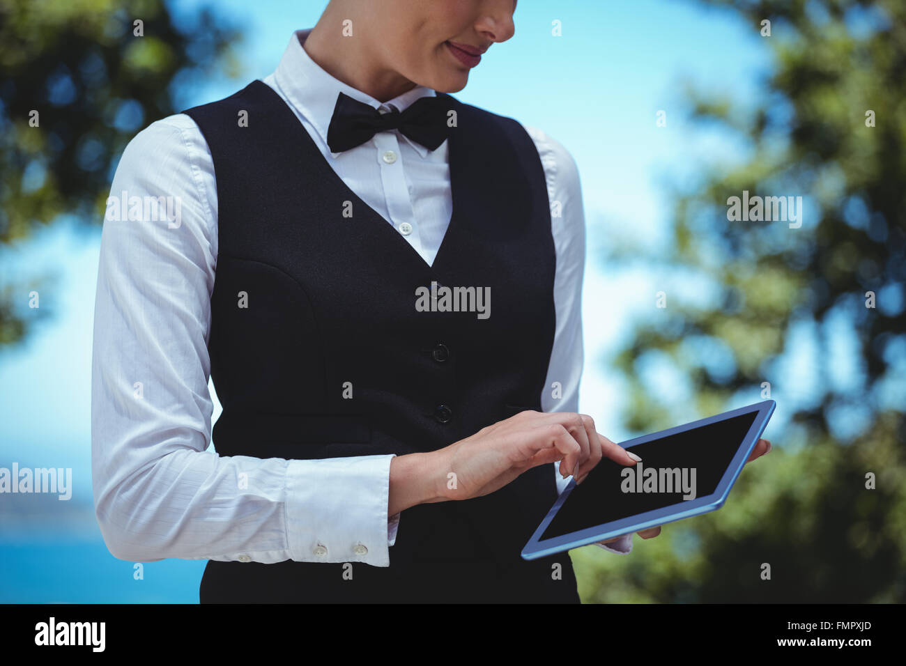 Smiling waitress taking an order with a tablet Stock Photo - Alamy