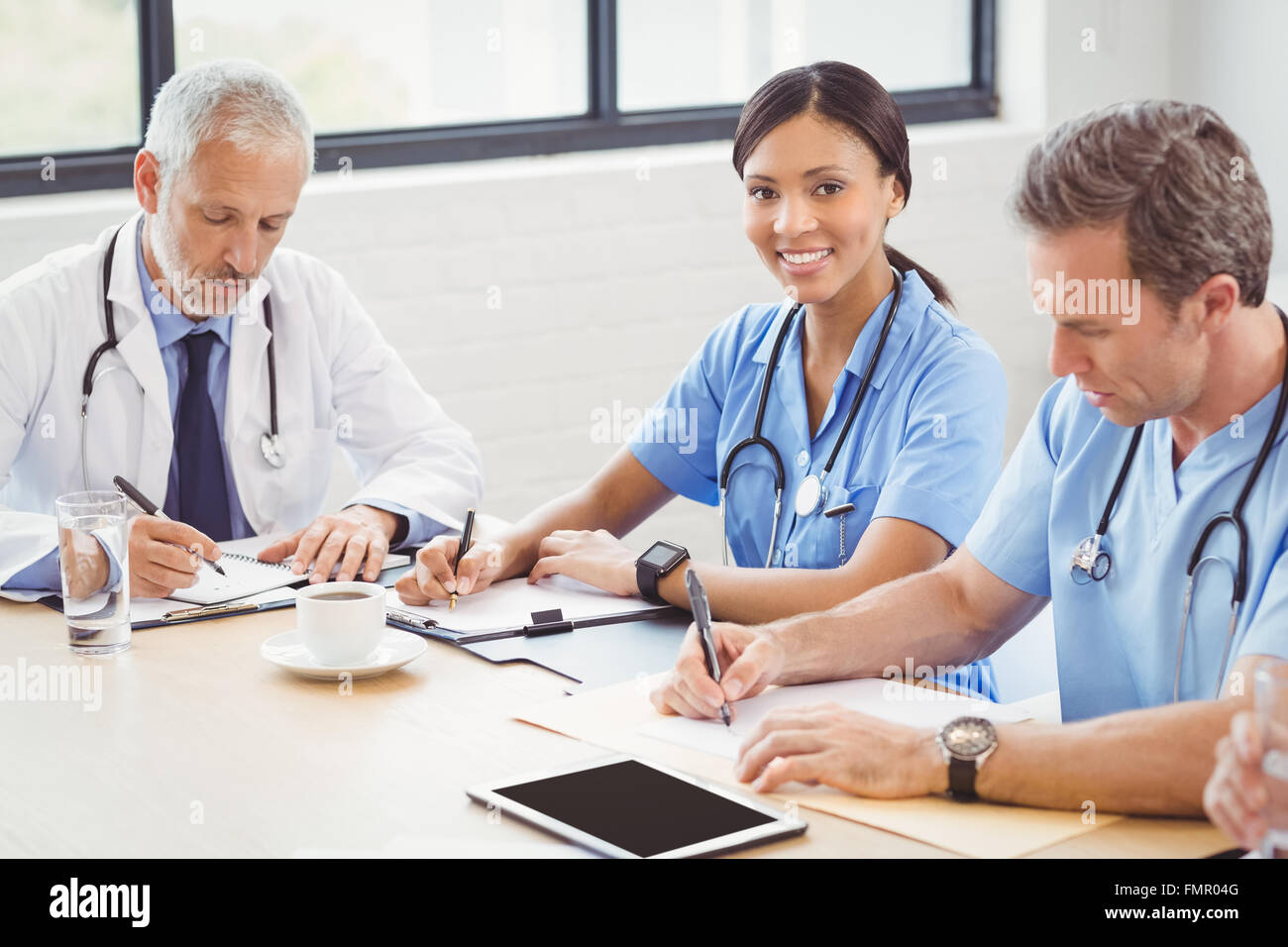 Medical team writing a report in conference room Stock Photo - Alamy