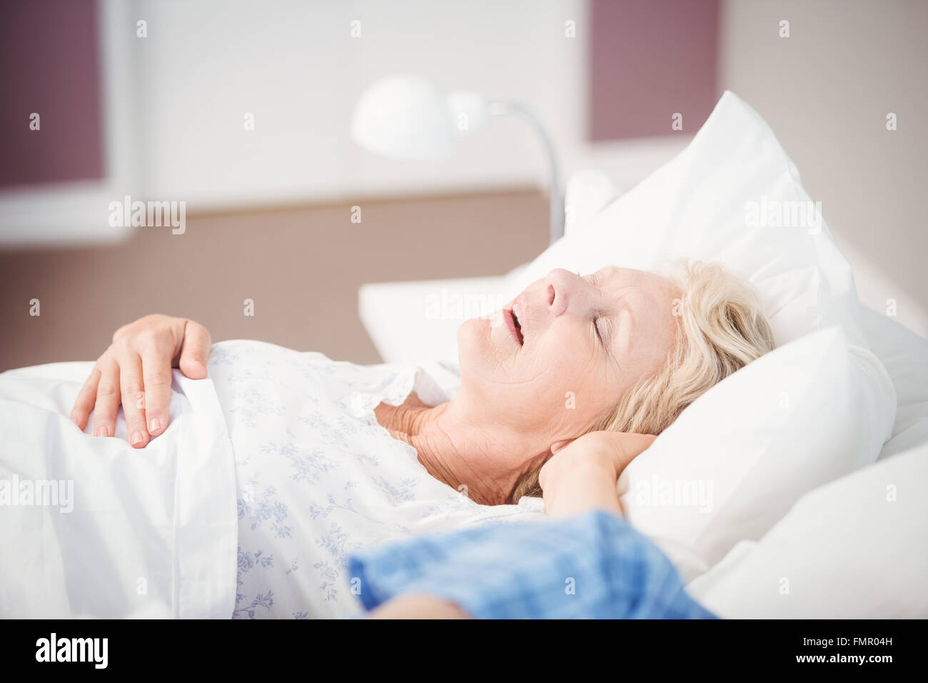 Woman snoring on bed next to husband Stock Photo - Alamy