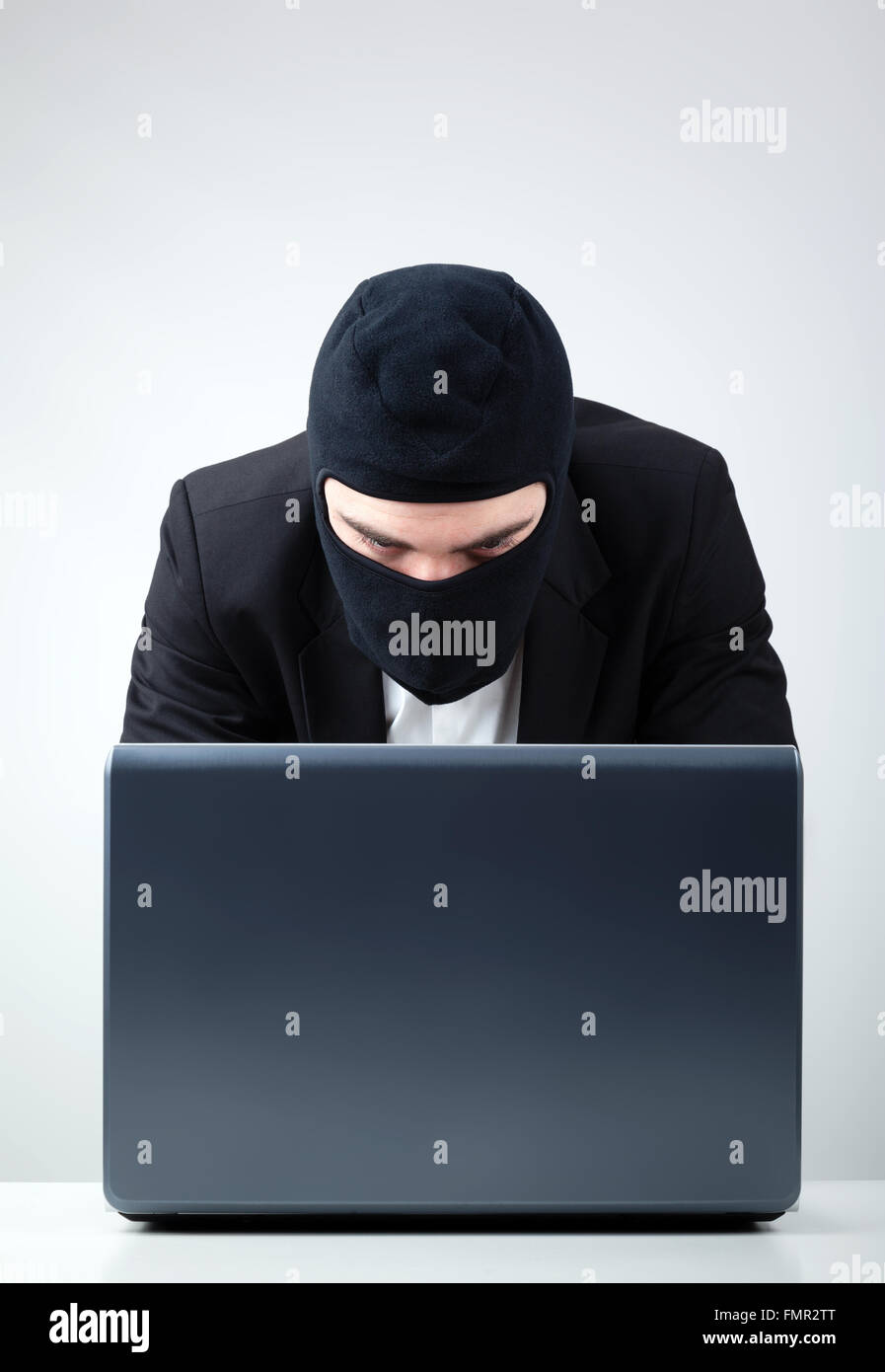 Portrait of a hacker with balaclava against grey background Stock Photo ...