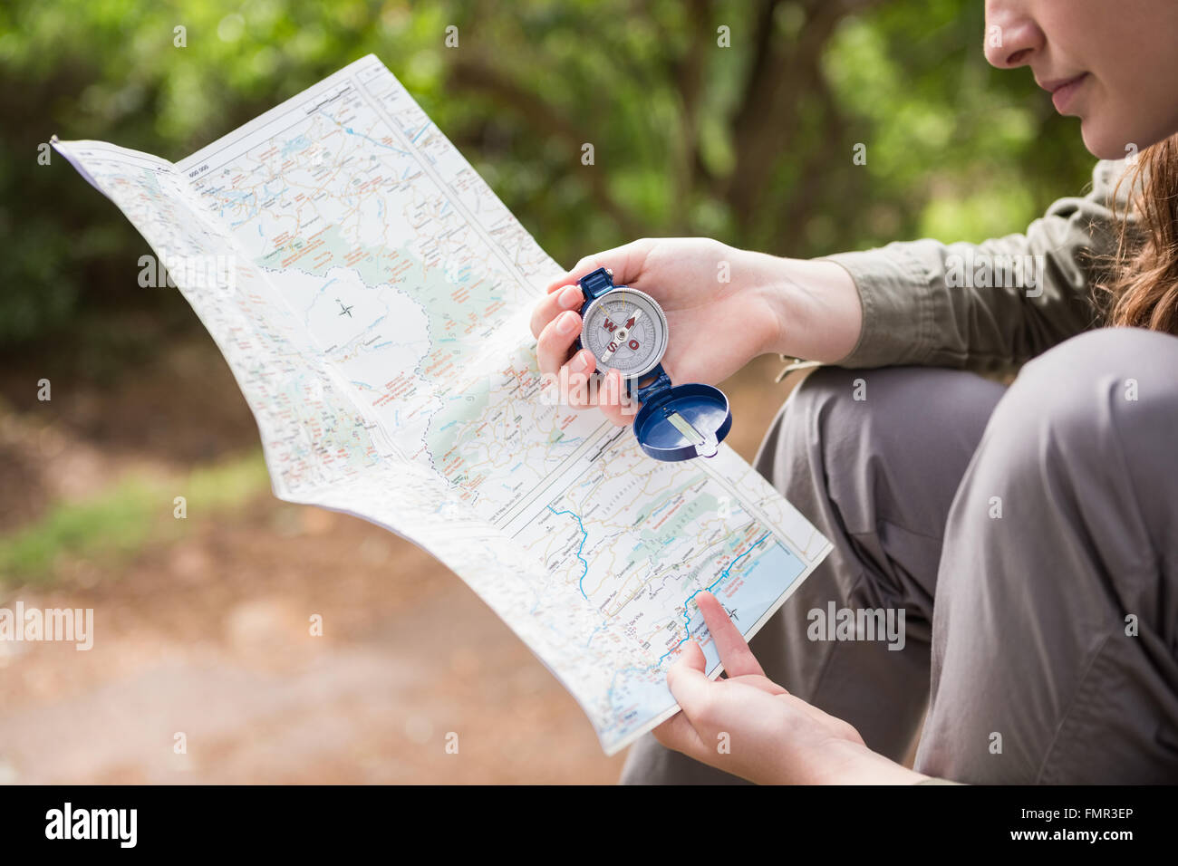 Woman checking map and compass Stock Photo - Alamy
