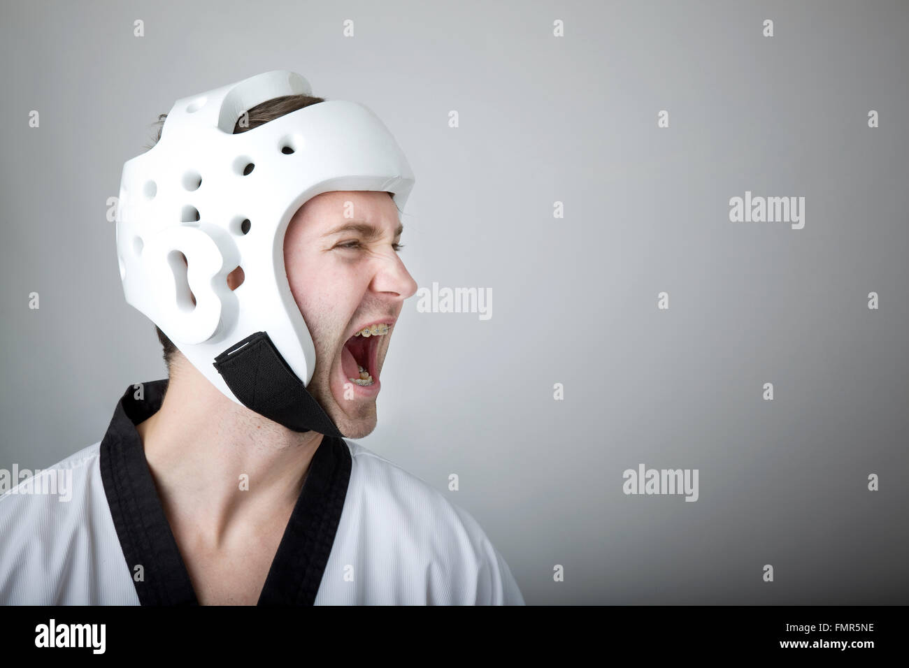 Young martial arts man shouting over gray background Stock Photo - Alamy