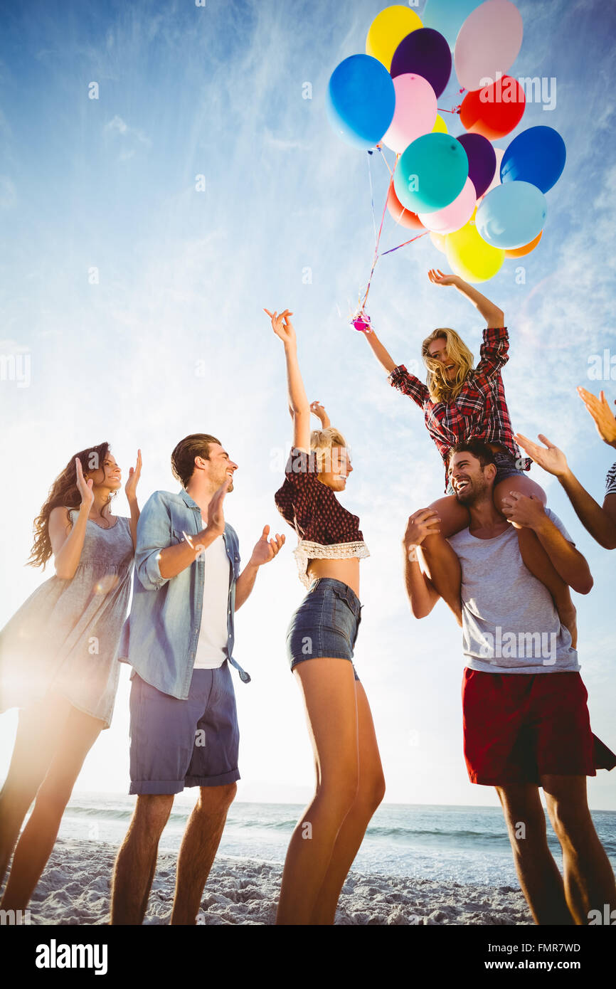 Friends dancing on sand with balloon Stock Photo - Alamy