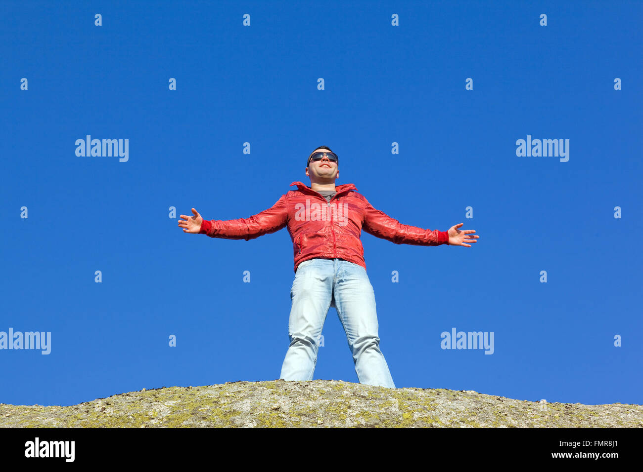 Handsome young man with arms wide open smiling against sky Stock Photo ...