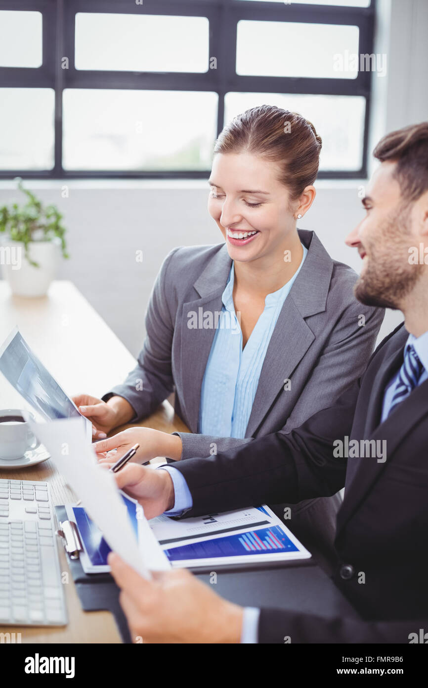 Business people smiling while discussing over documents Stock Photo - Alamy
