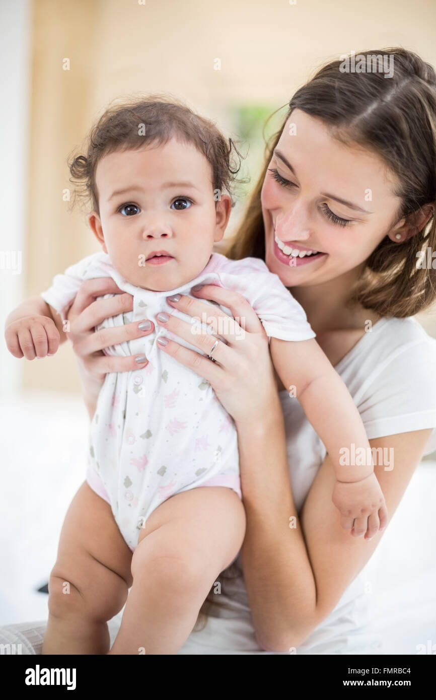 Smiling mother holding cute baby Stock Photo - Alamy