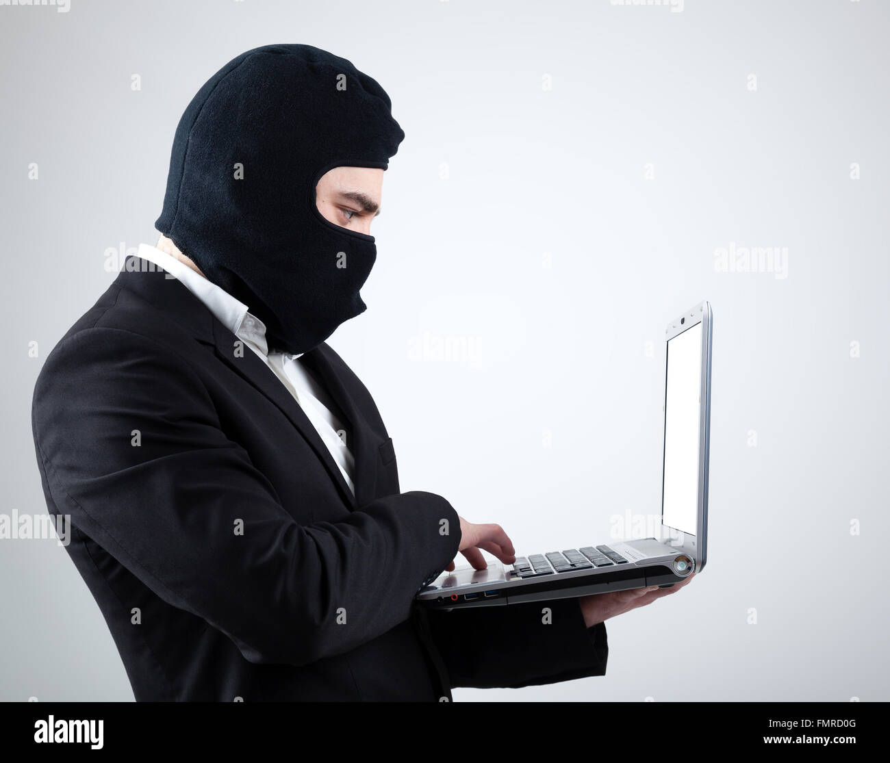Portrait of a hacker with balaclava against grey background Stock Photo ...