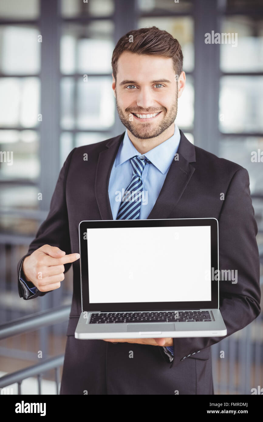 Happy businessman showing laptop Stock Photo - Alamy