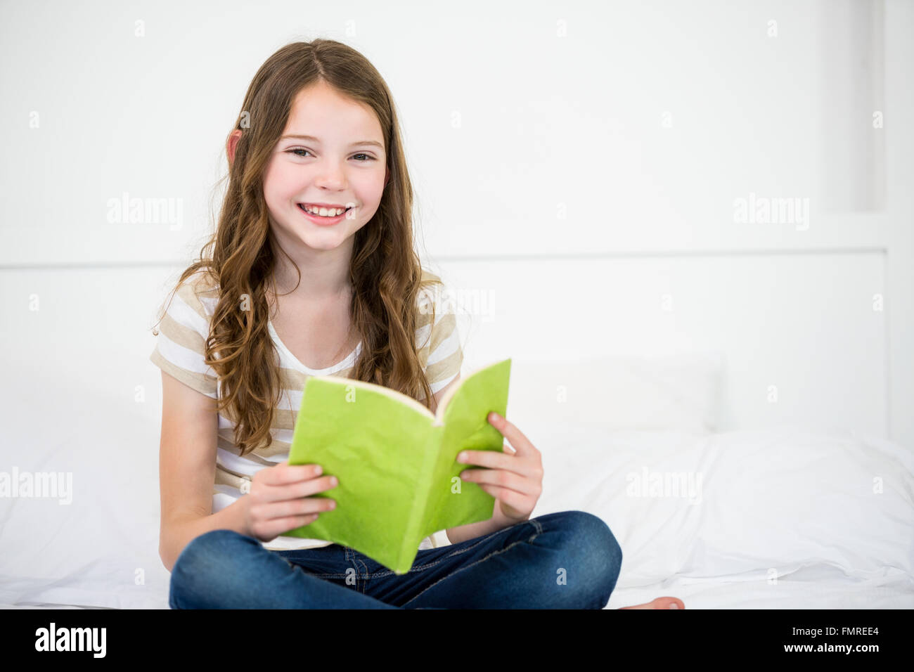 Cute happy girl reading book on bed Stock Photo - Alamy