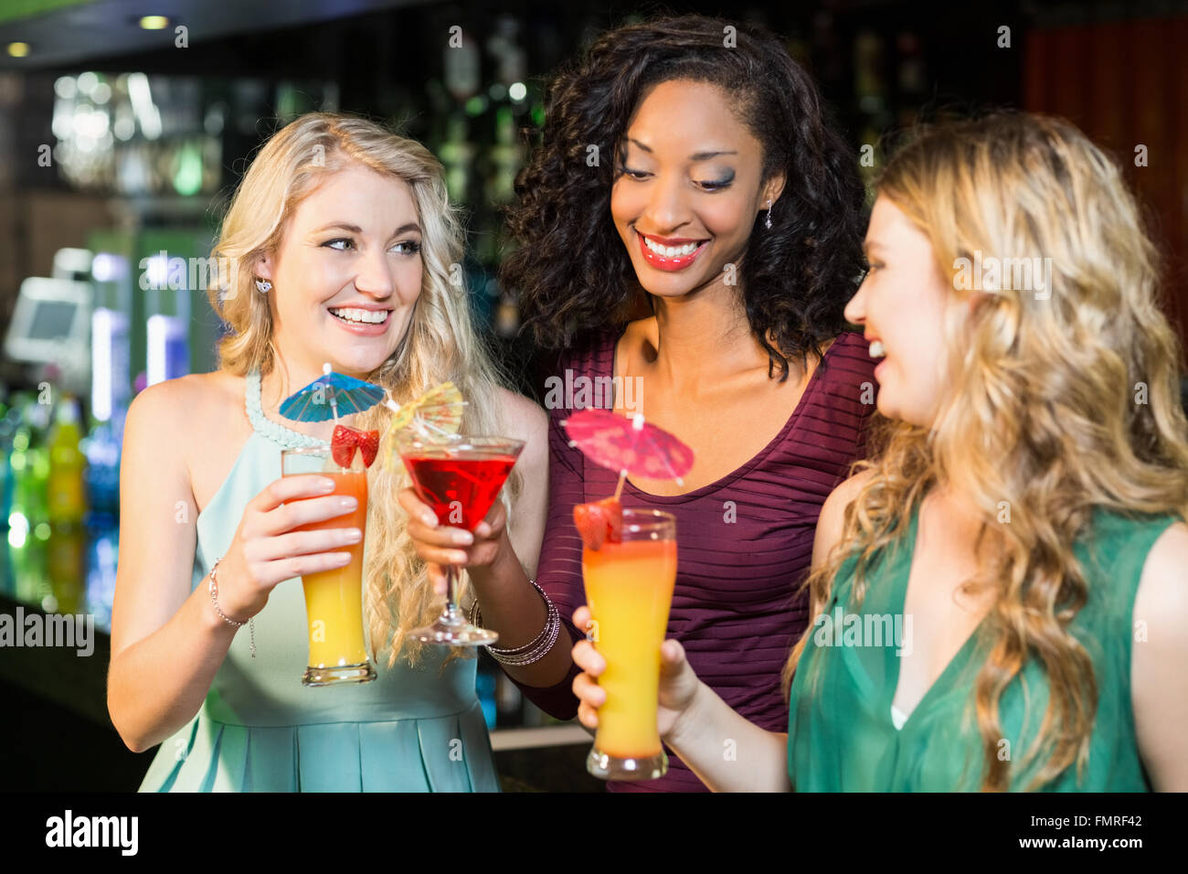 Happy friends drinking cocktails Stock Photo - Alamy