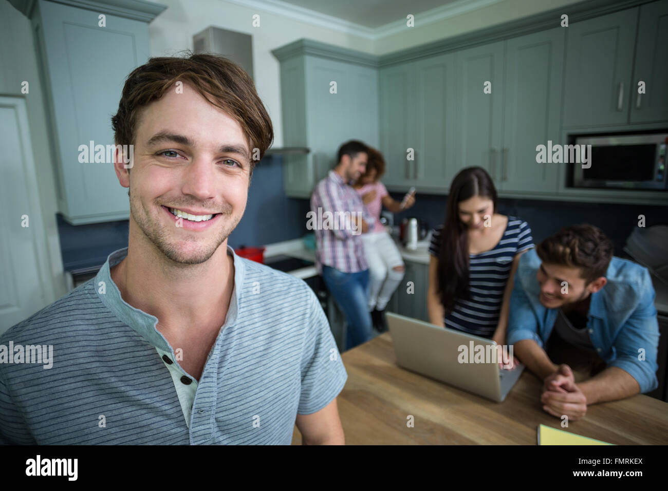 Portrait of happy man with friends in background at home Stock Photo ...