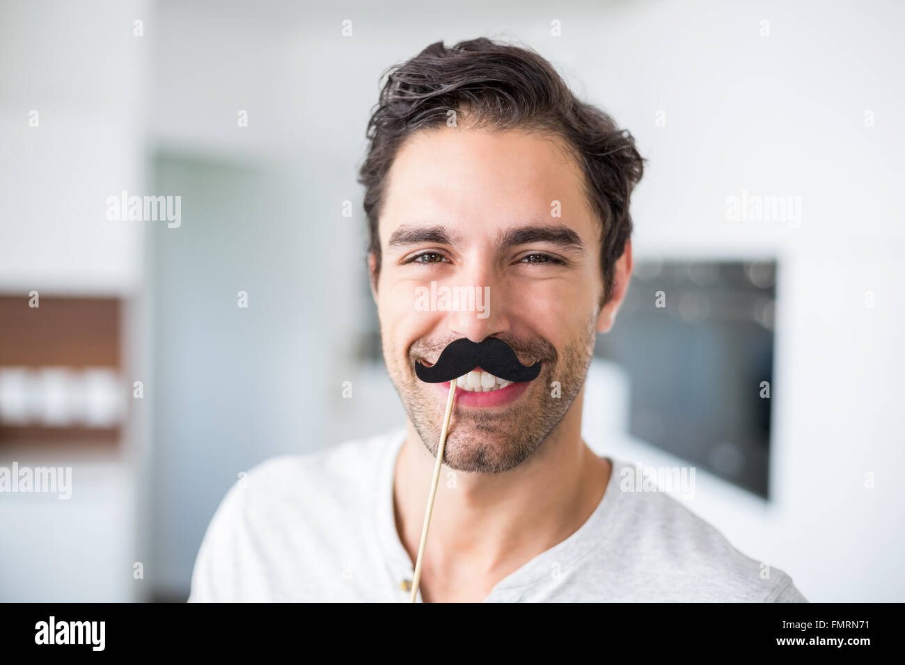 Portrait of smiling man with artificial mustache Stock Photo - Alamy