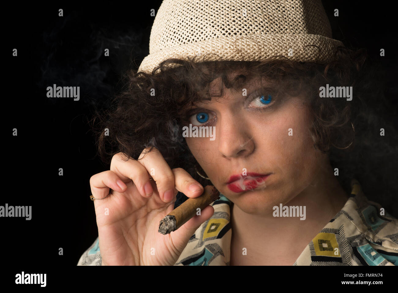 Pretty young Caucasian woman smoking cigar with come hither look at ...