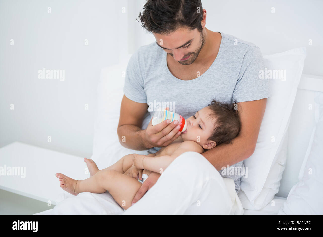 Man feeding milk to baby girl Stock Photo - Alamy