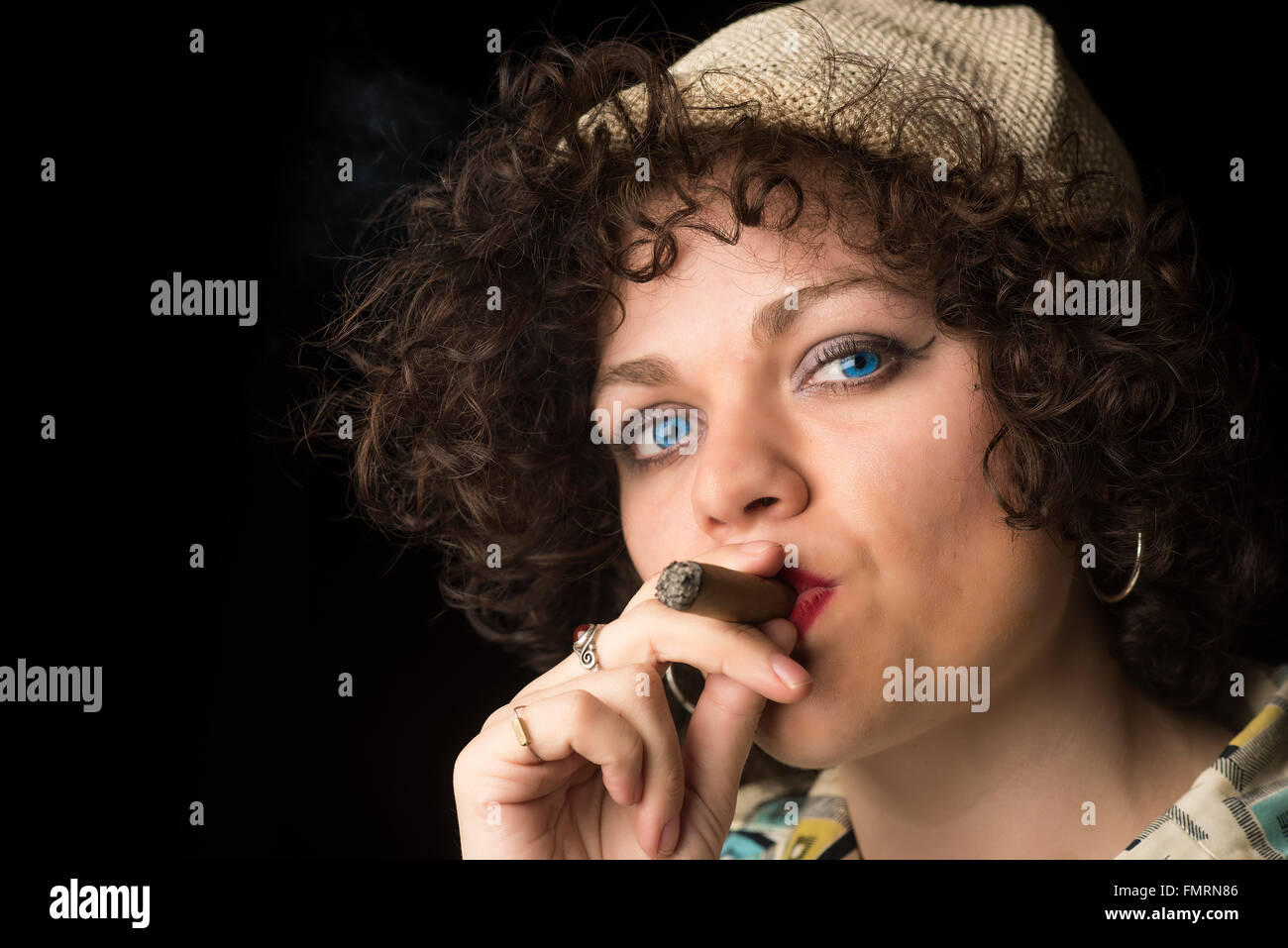 Pretty young Caucasian woman smoking cigar with come hither look at ...