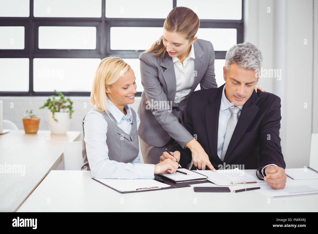 Business people explaining client with documents Stock Photo - Alamy