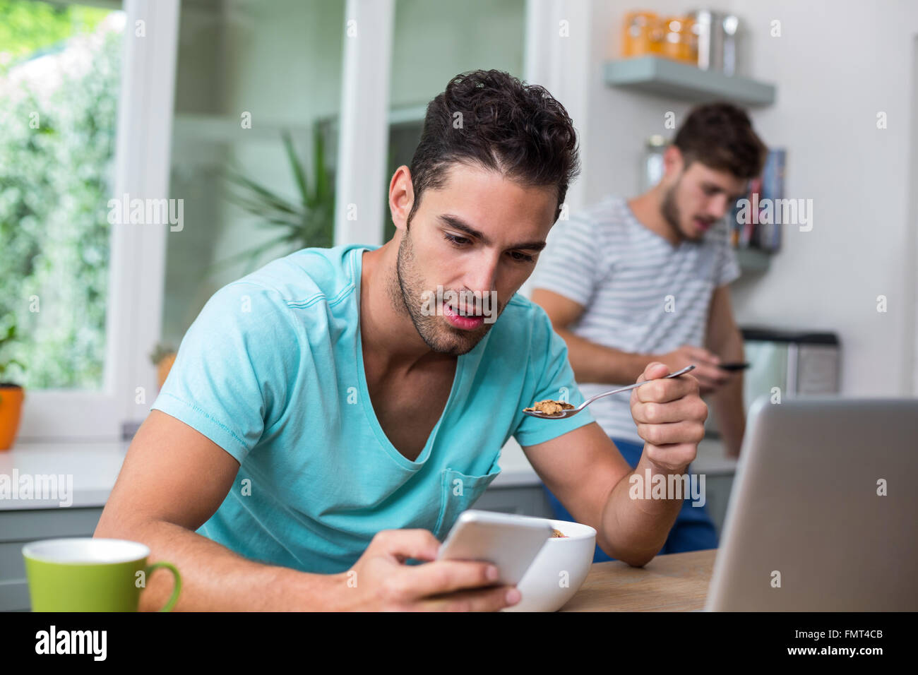Man using phone while having food at table Stock Photo - Alamy