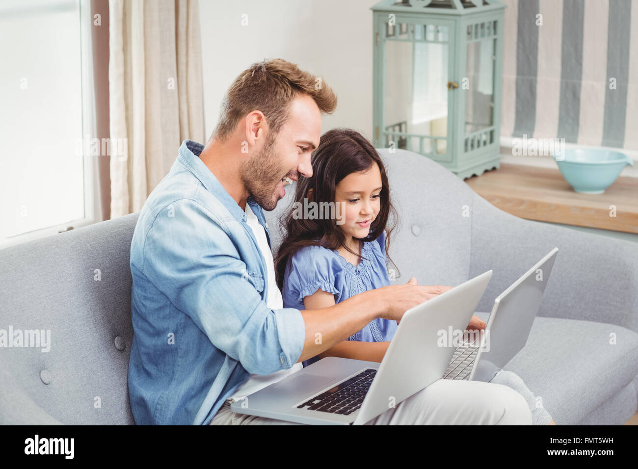 Father assisting daughter in using laptop Stock Photo - Alamy