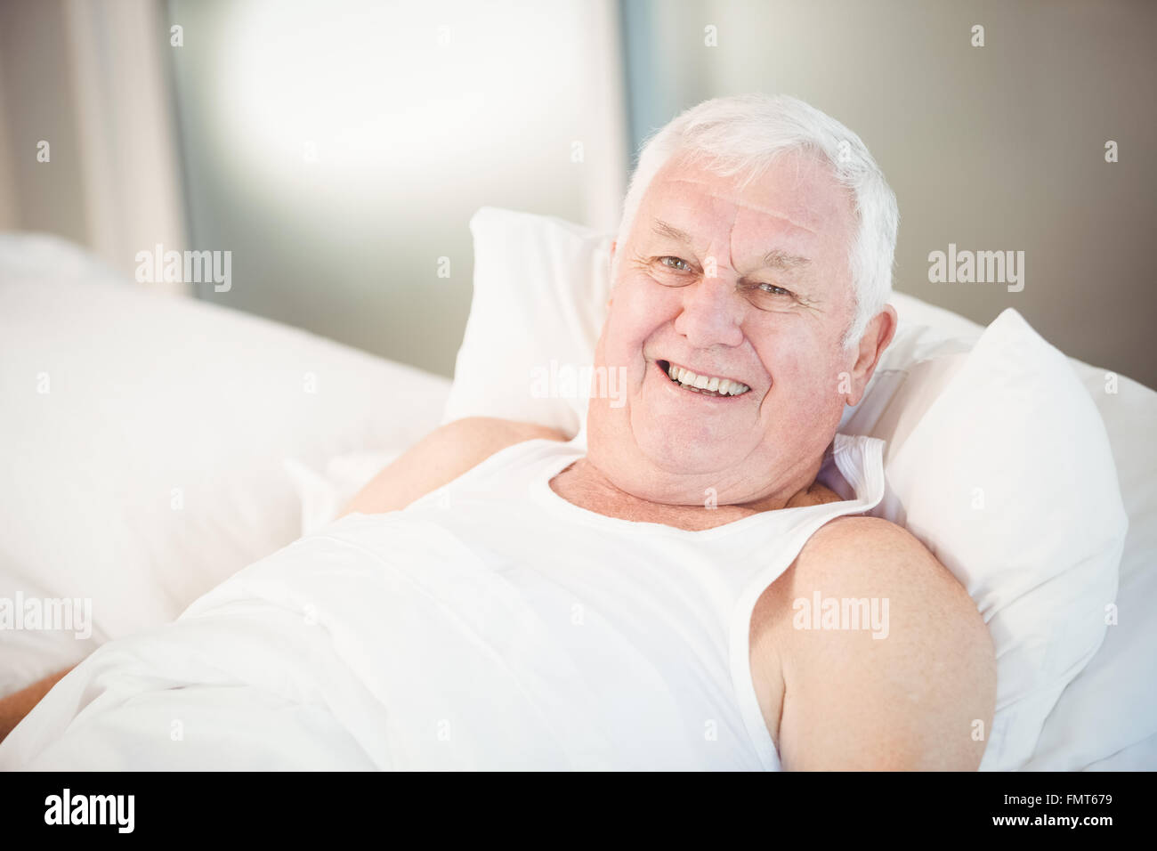 Portrait of senior man relaxing on bed Stock Photo - Alamy