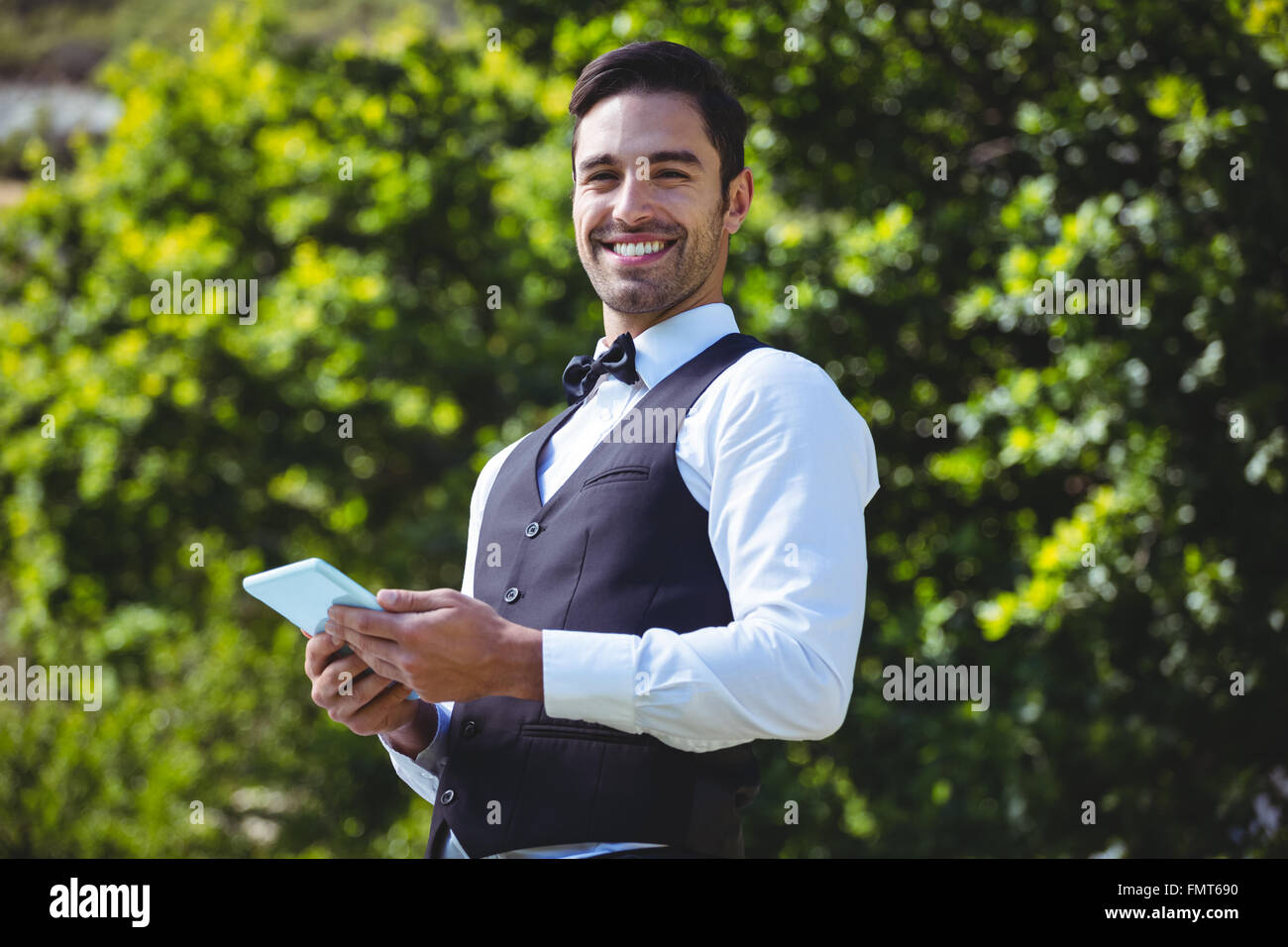 Handsome waiter using tablet computer Stock Photo - Alamy