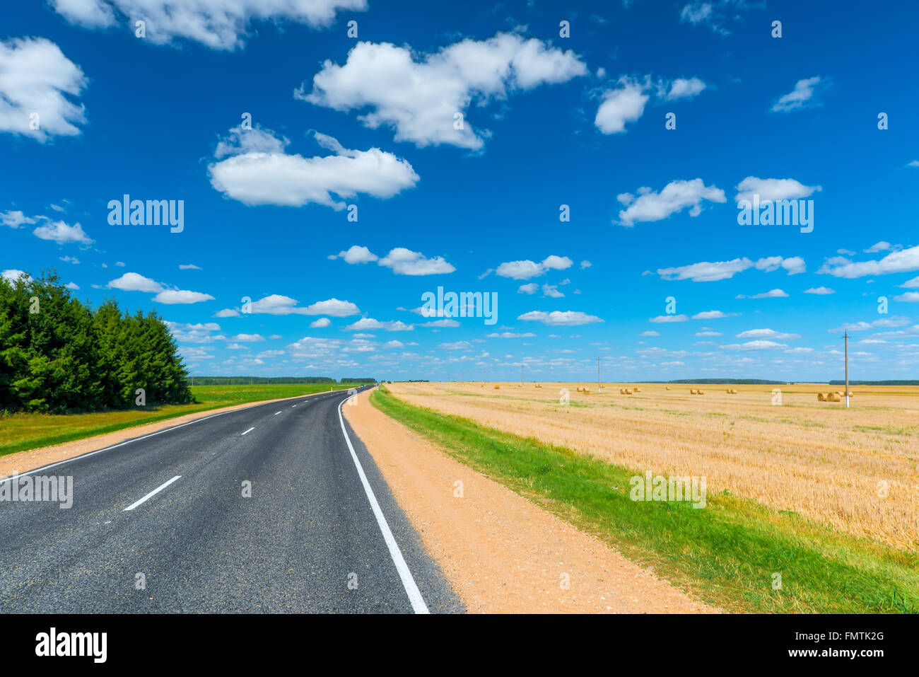 road in the countryside and beautiful wheat field after harvest Stock ...