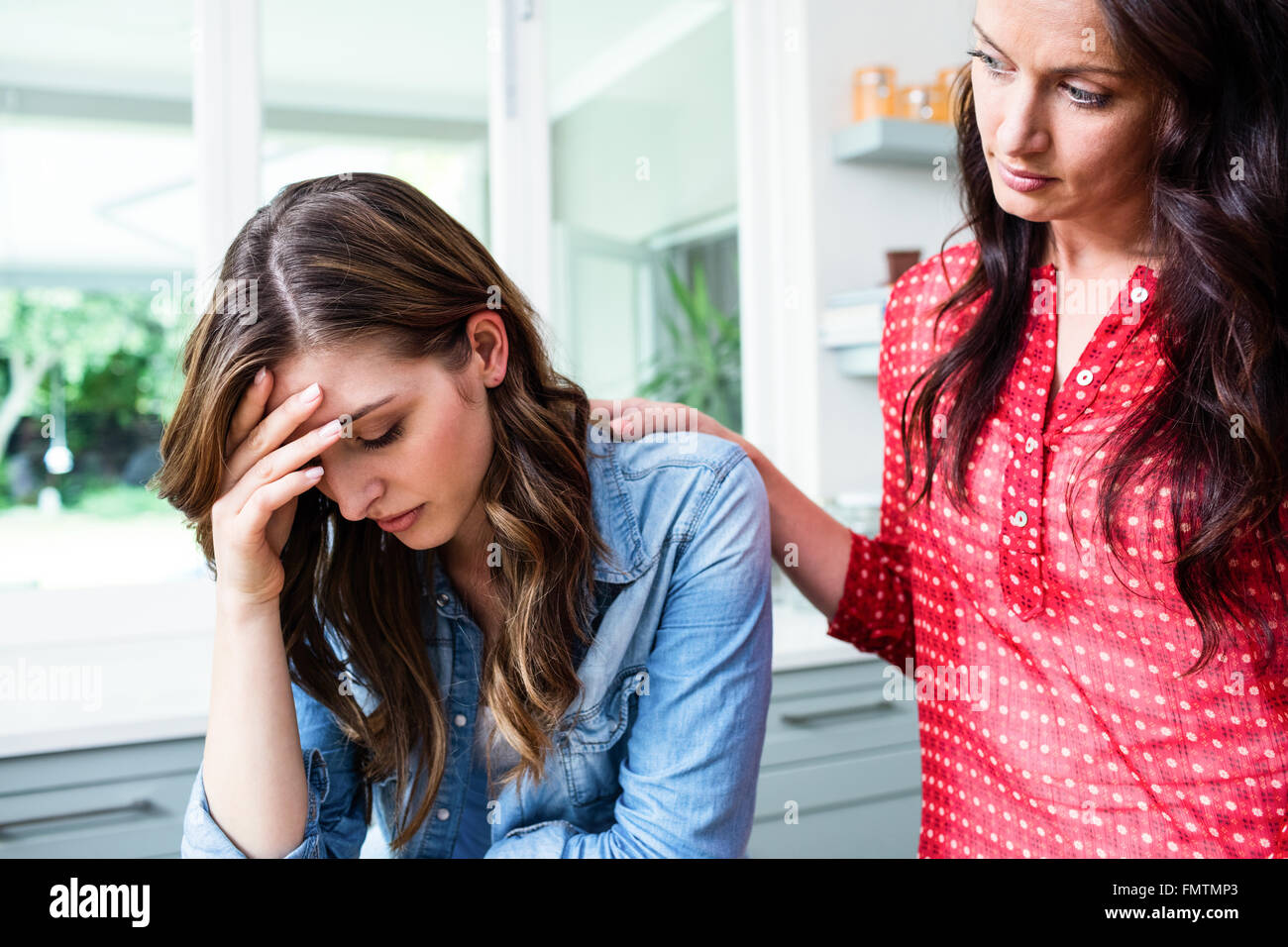 Worried young woman with friend Stock Photo - Alamy