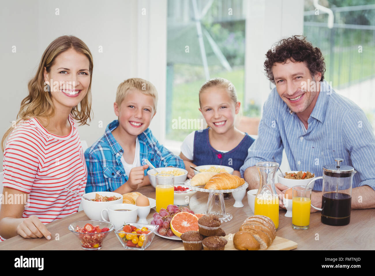 Happy family having breakfast at table Stock Photo - Alamy
