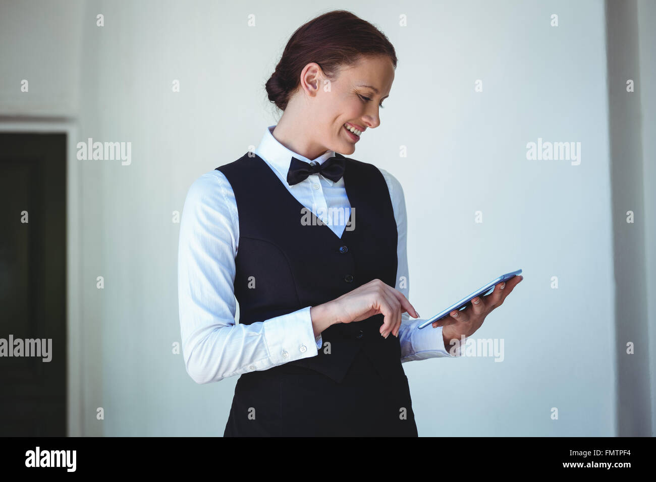 Smiling waitress using a tablet Stock Photo - Alamy
