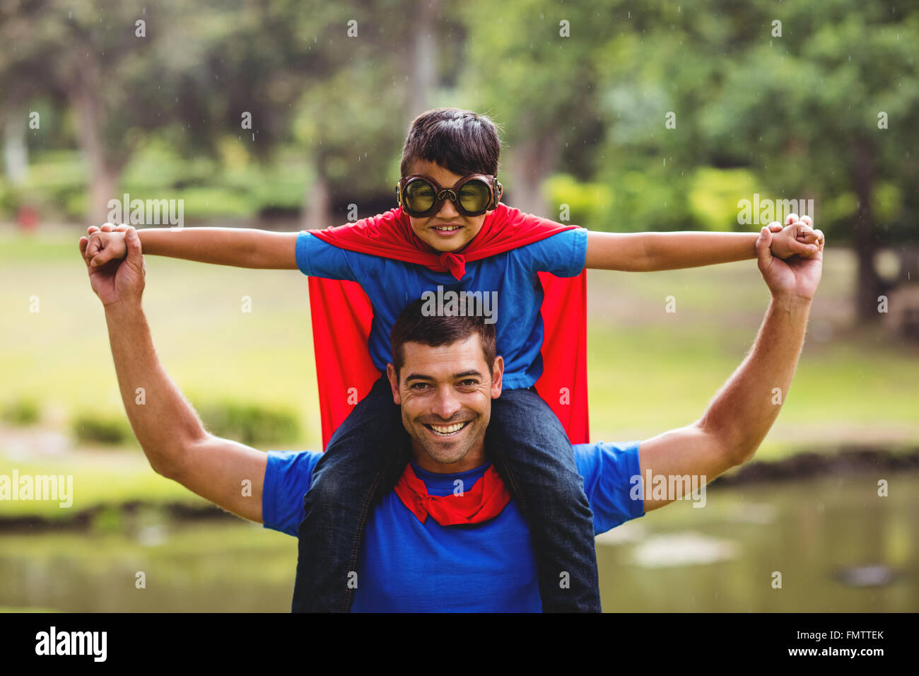 Boy in superhero costume sitting on fathers shoulder Stock Photo - Alamy